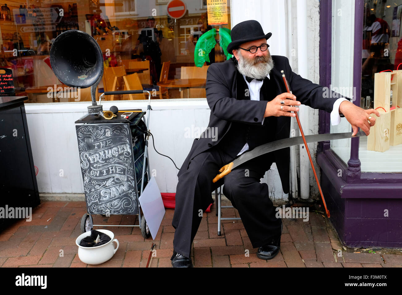 Man playing saw busker high street pot hat record player gramaphone ...