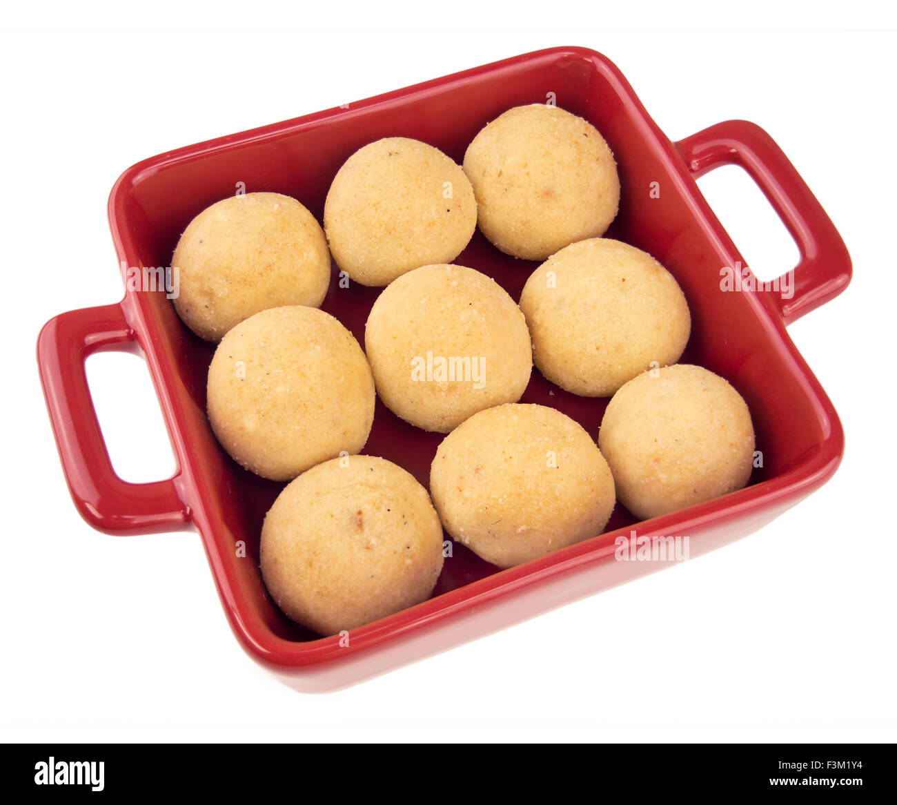 Indian laddu (ladoo) dessert sweets arranged in a red square dish ...