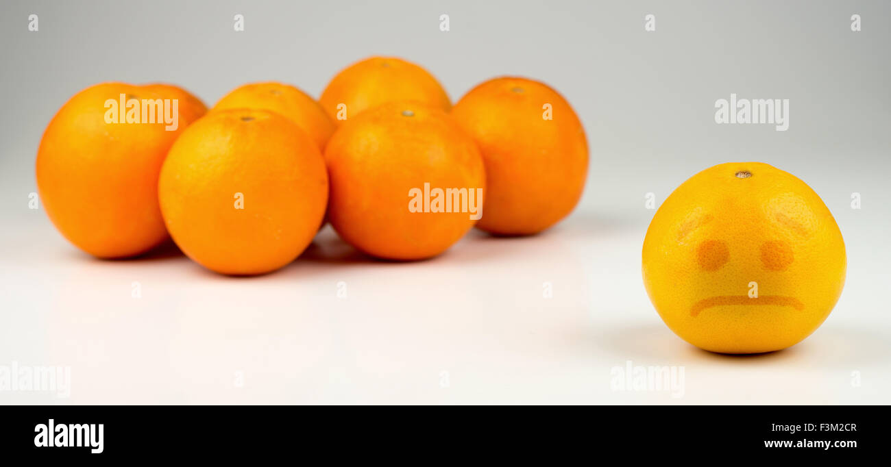 Sad orange ostracized by darker, taller oranges Stock Photo - Alamy