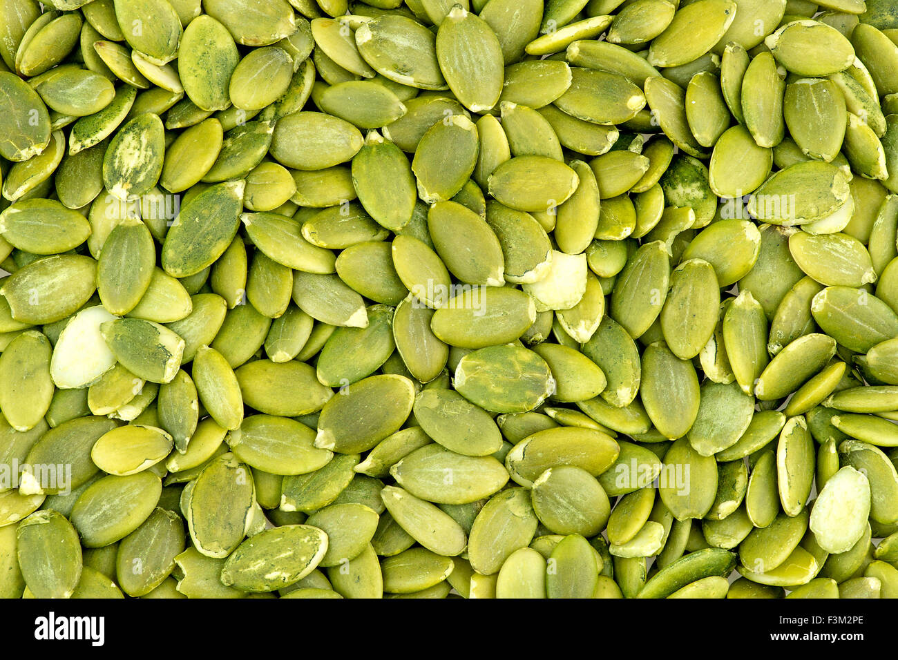 Macro background texture of green pumpkin seeds Stock Photo - Alamy