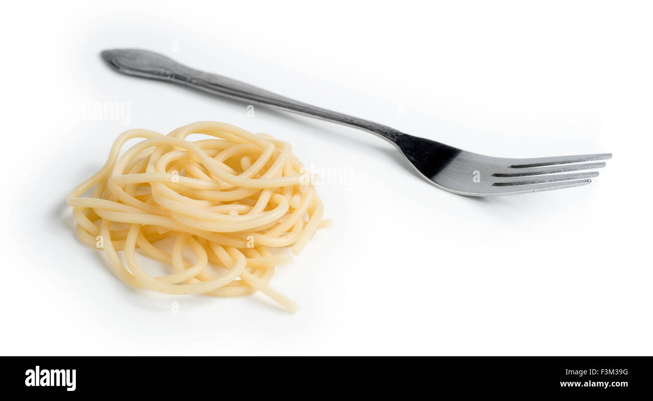 Macro of swirl of cooked spaghetti with fork isolated against white ...