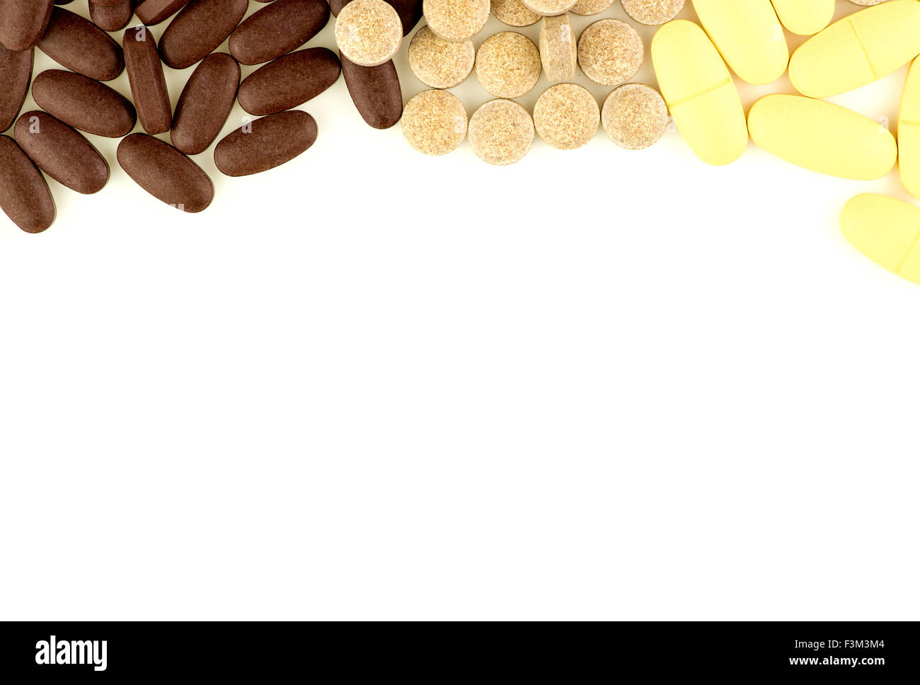 Multi colored pills scattered on white background with aerial view ...