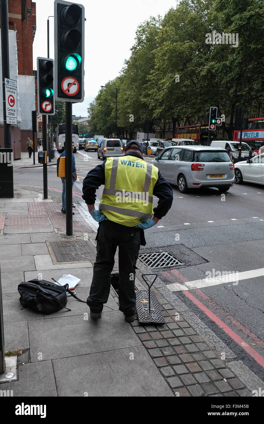 Man from water company pulling up drain covers in London street Stock ...