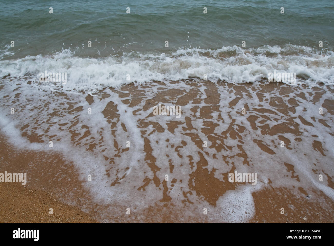 Sea wave over sand Stock Photo - Alamy