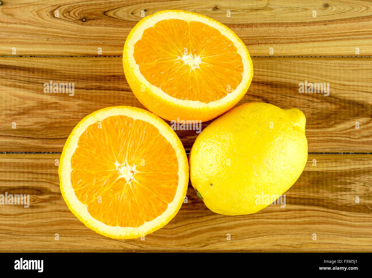 Orange fruit halves with lemon on wood Stock Photo - Alamy