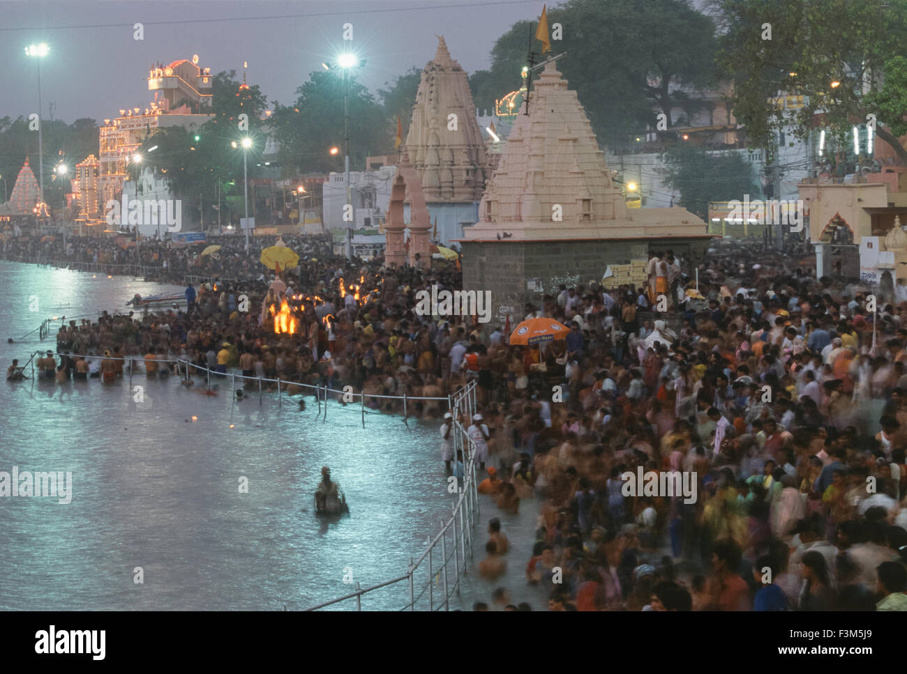 Bathing pilgrims thronging the ghats of the Shipra River during evening ...
