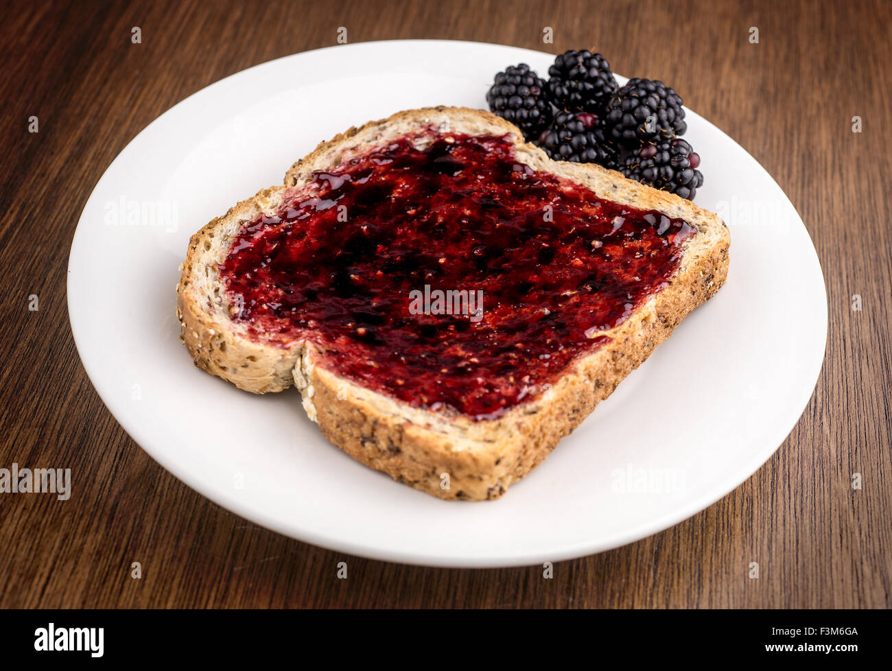 Blackberries with blackberry jam on whole wheat toast Stock Photo - Alamy