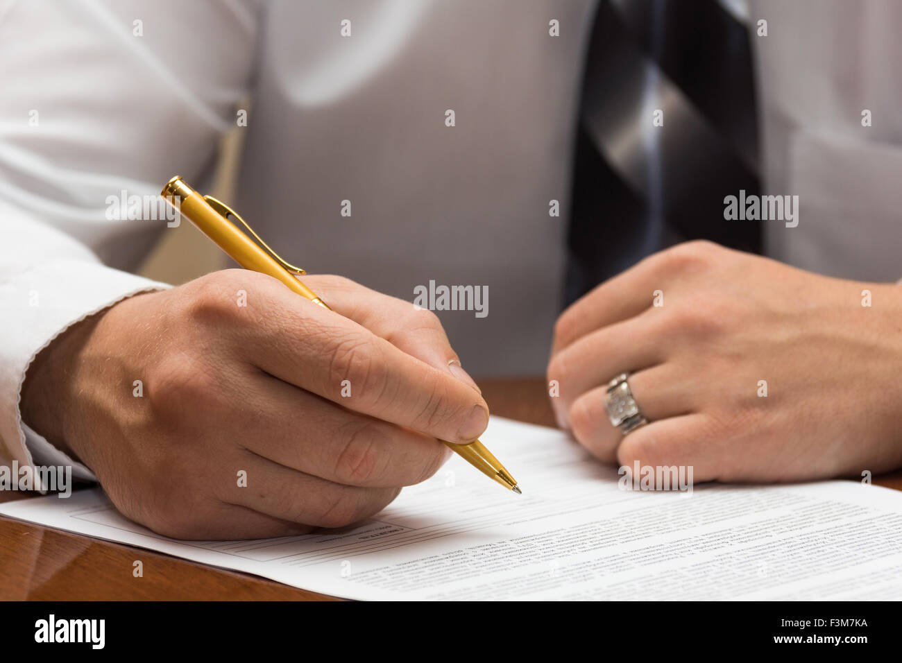 The photo depicts a man signs a document Stock Photo - Alamy