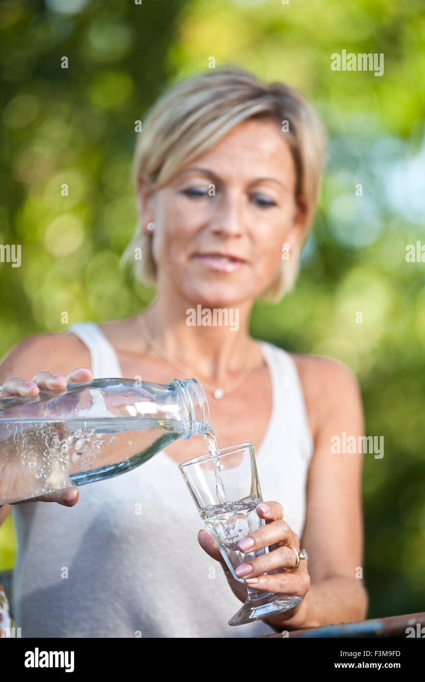 Woman pouring water glass hi-res stock photography and images - Alamy
