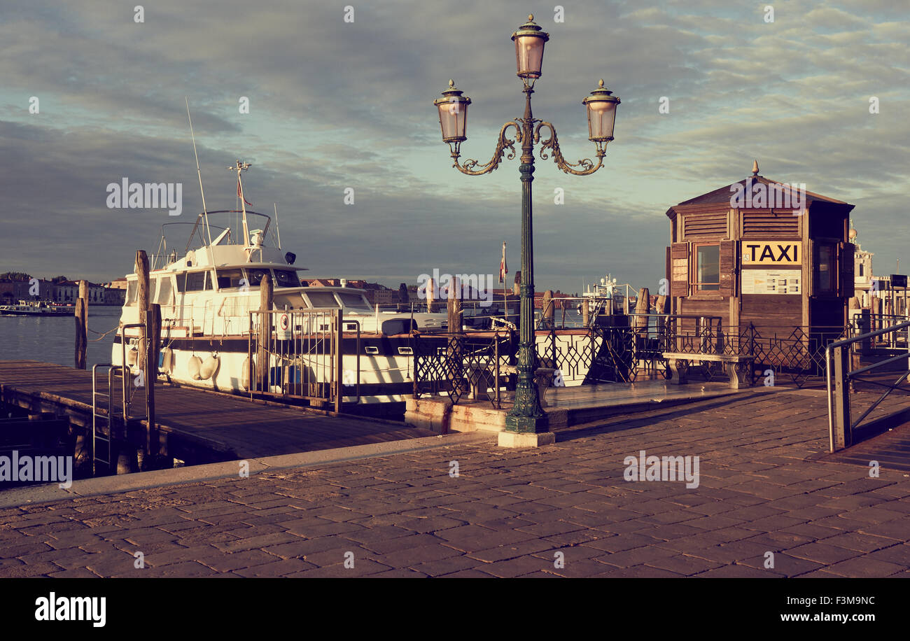Warm dawn sunlight on the Venetian waterfront with water taxi office ...