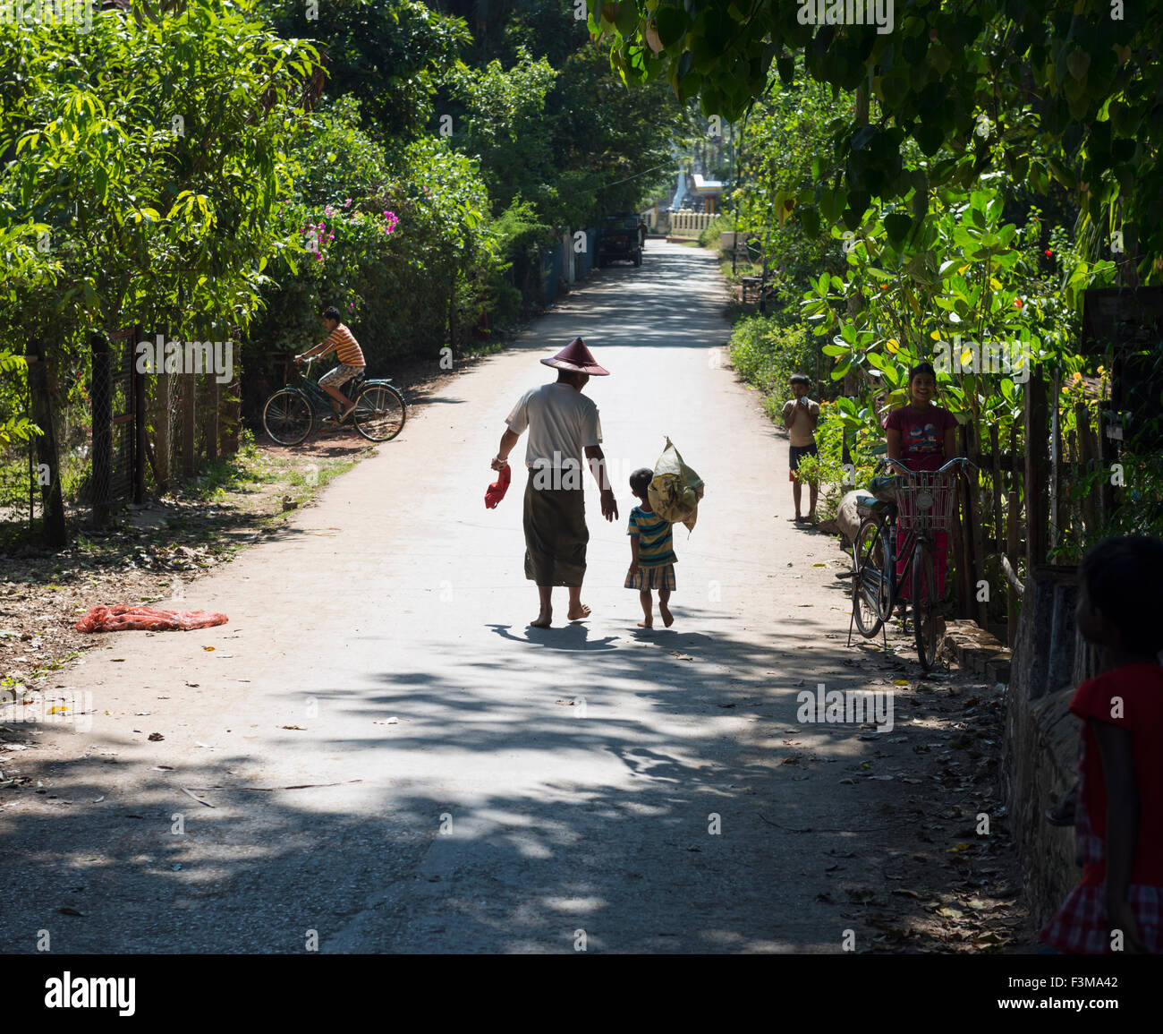 Man and child on village street, Burma Stock Photo - Alamy