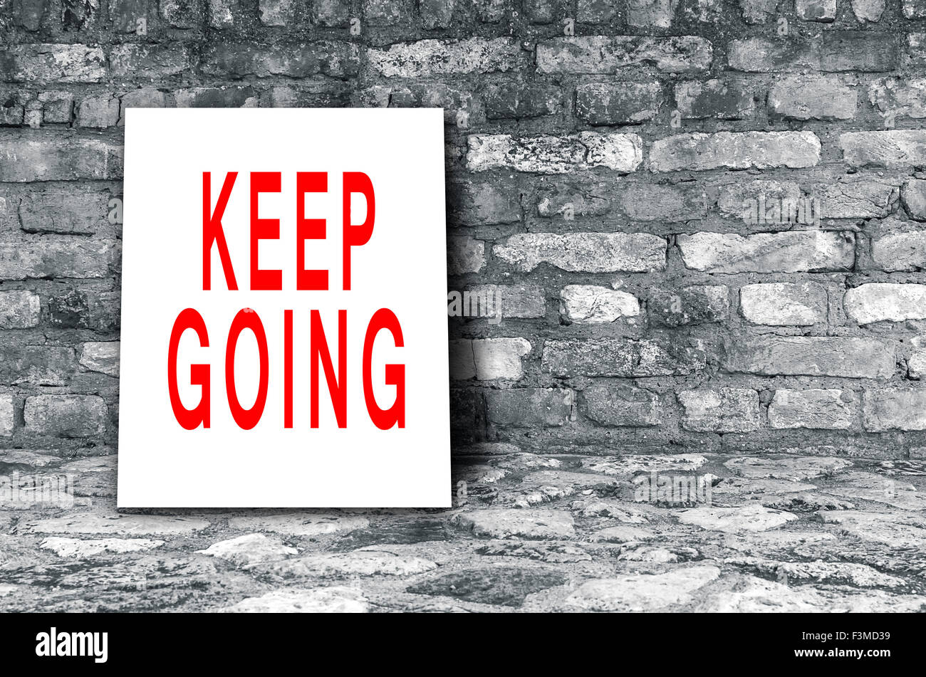 Keep Going sign on floor in black interior Stock Photo - Alamy