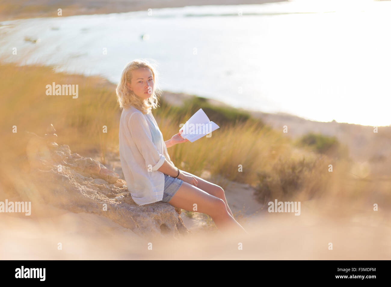 Woman enjoys reading on beautiful sandy beach Stock Photo - Alamy