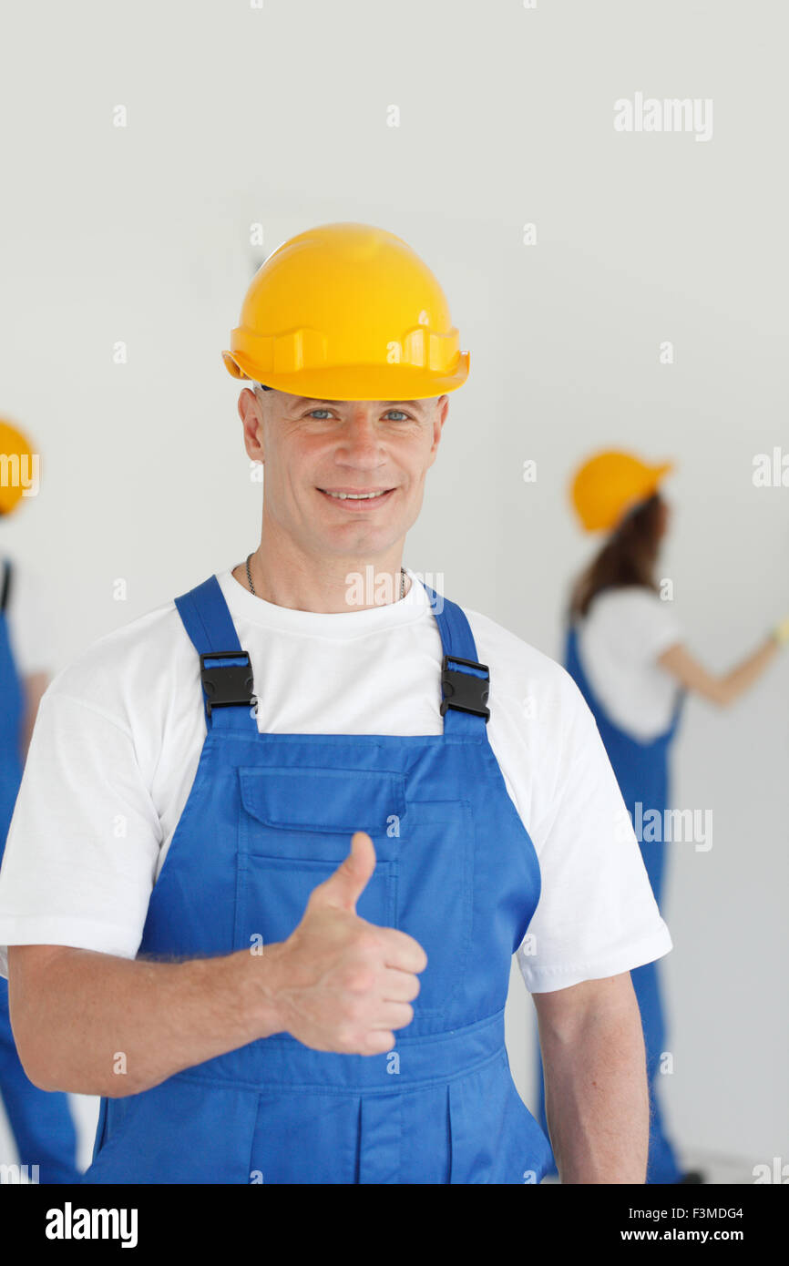 Manual worker with thumb up sign, Indoors Stock Photo - Alamy