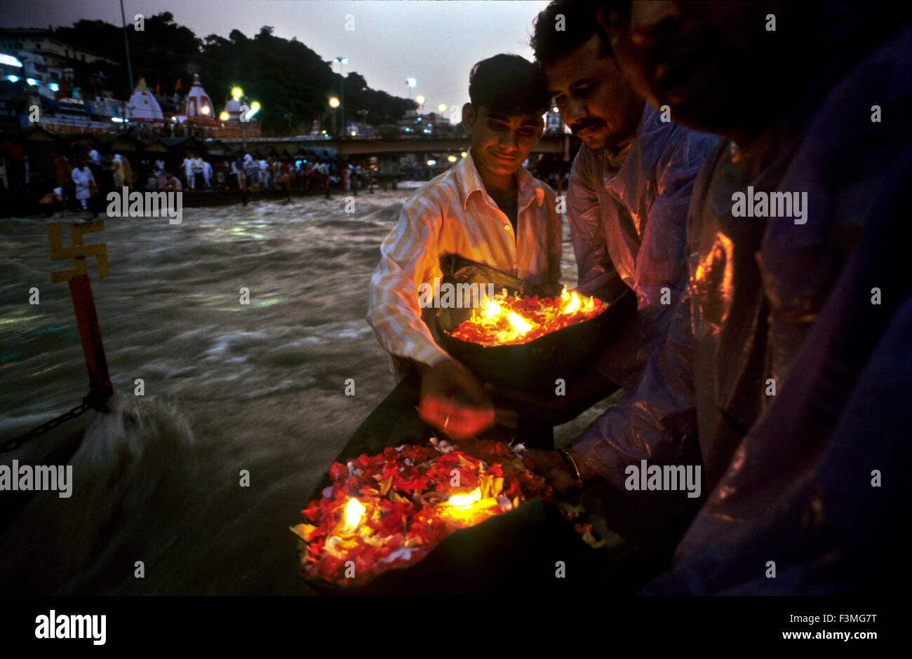 People offering a deepak (floating flowers and oil lamp) to the Ganges ...