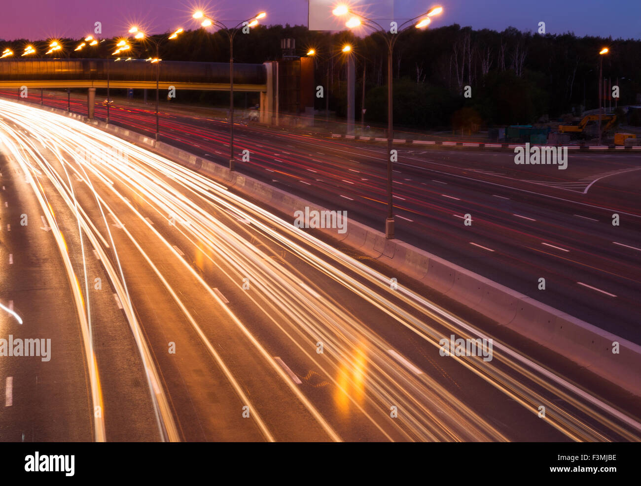 Illuminated highway at evening with light trails Stock Photo - Alamy