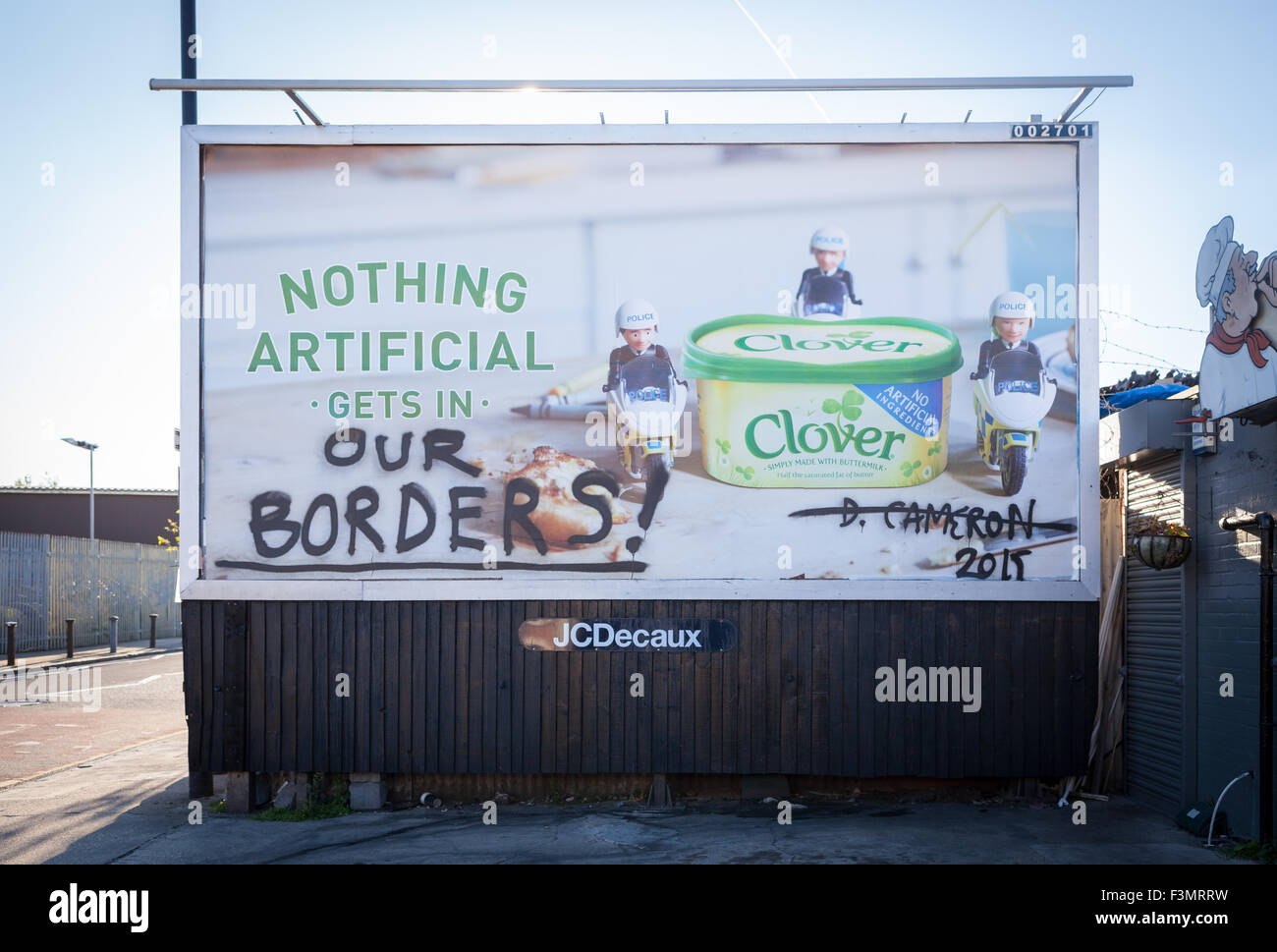 A clover poster graffitied with 'Nothing Artificial Gets in Our Borders ...
