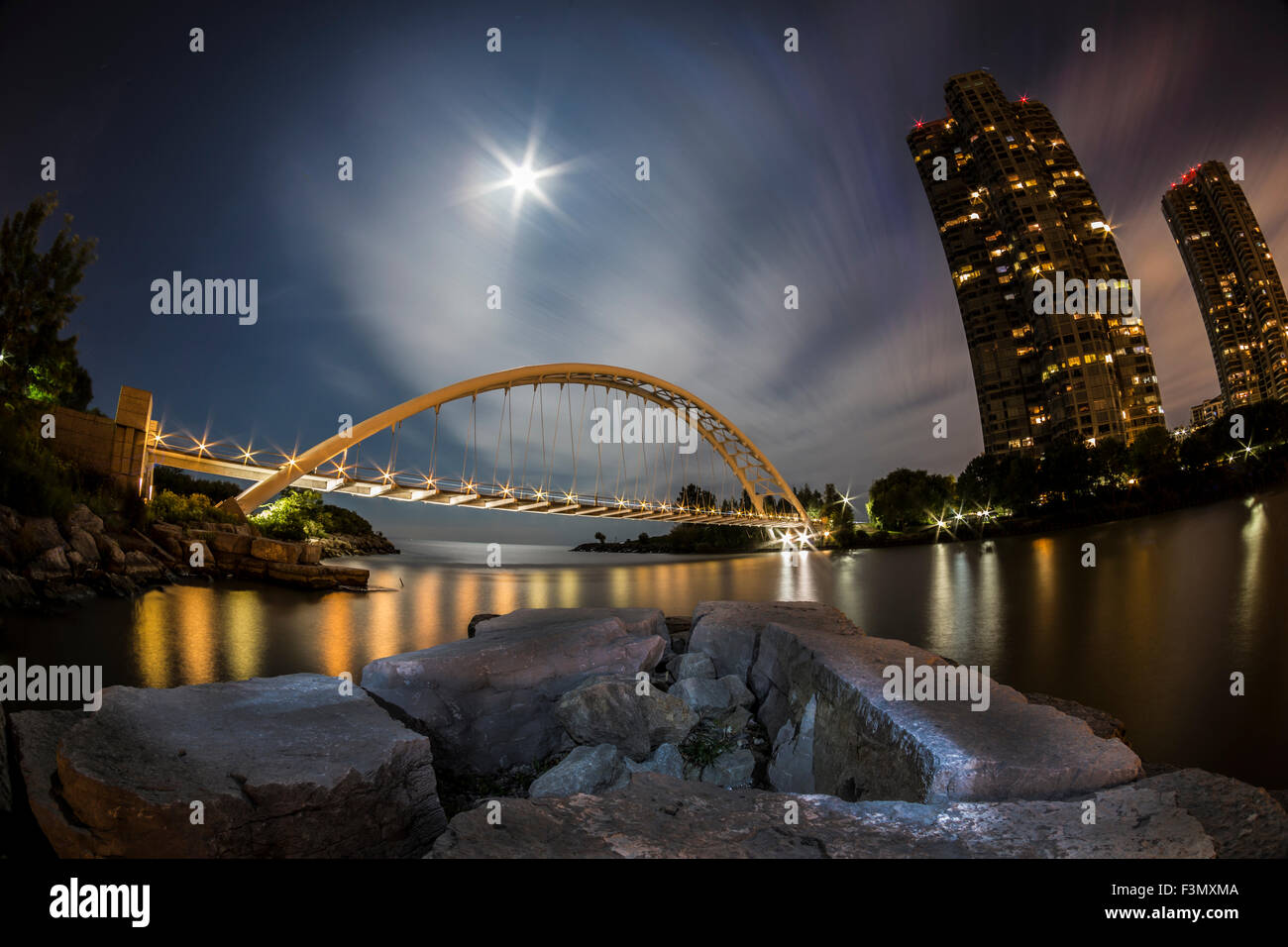 Illuminated arch bridge at night with a harvest moon Stock Photo - Alamy