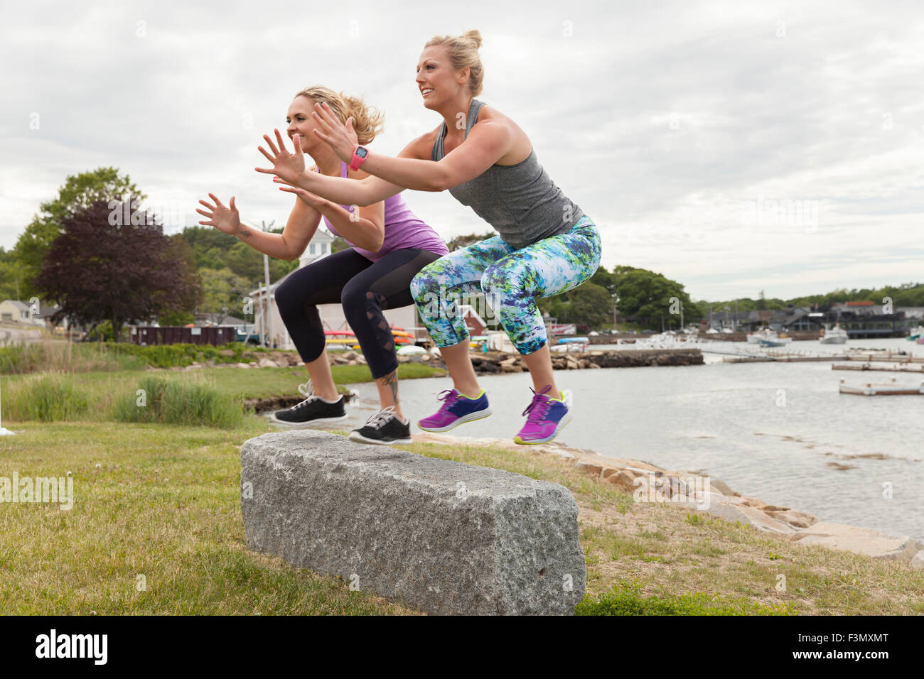 Two women jumping Stock Photo - Alamy