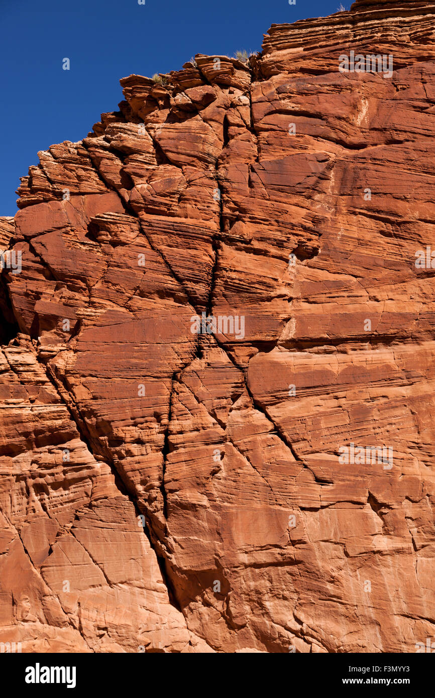 A steep orange sandstone cliff inside of Canyon X with a natural crack ...