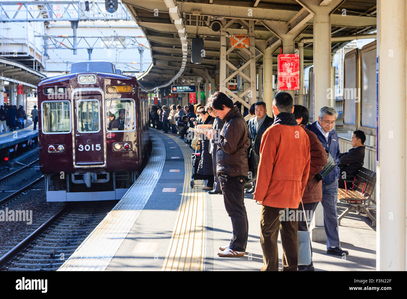 Japan, Osaka, Hankju Juso railway station. Passengers waiting on ...