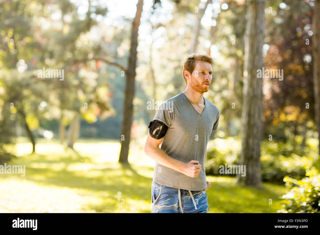 Young man running in the autumn park Stock Photo - Alamy