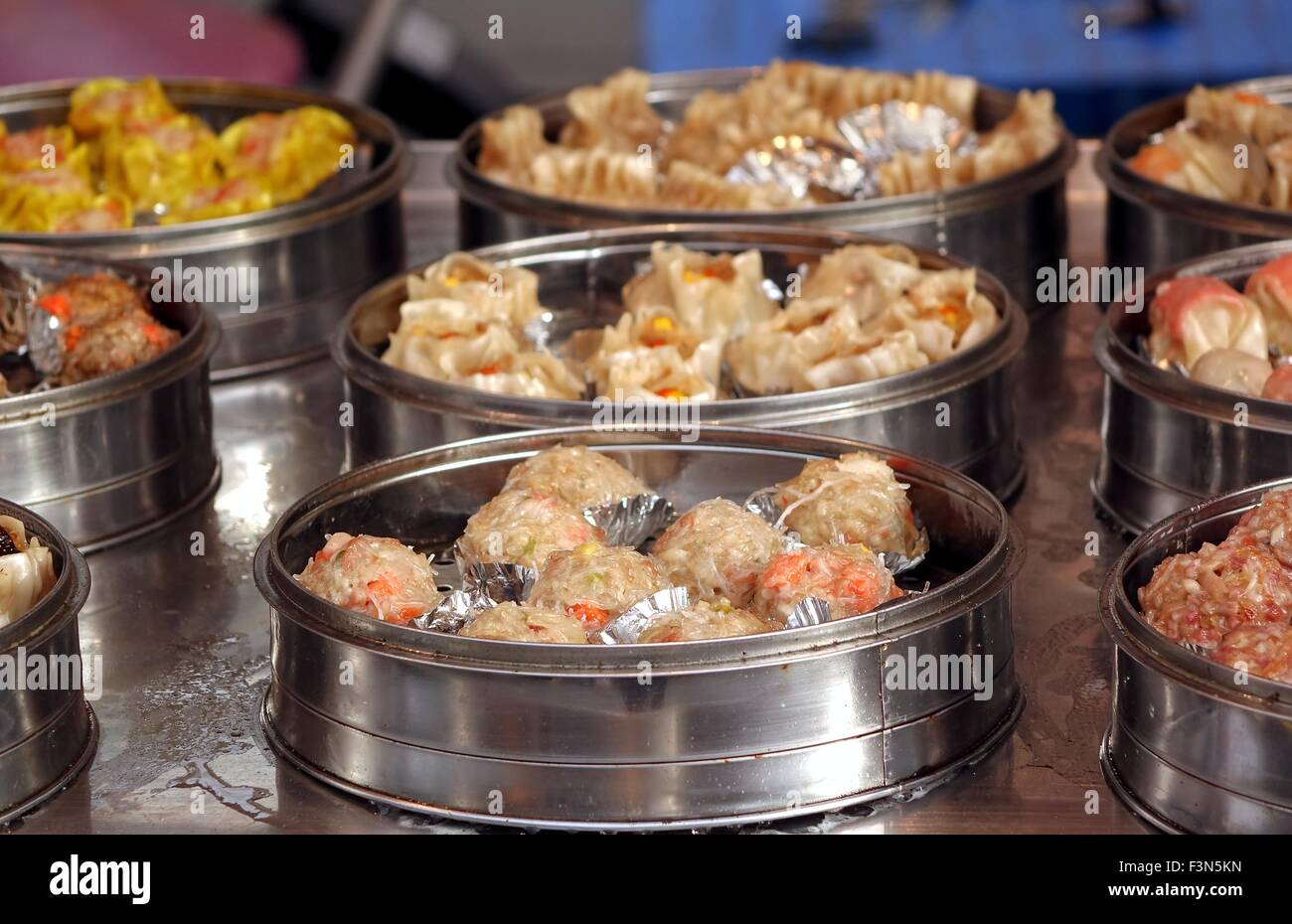 An outdoor vendor sells Cantonese Dim Sum dishes cooked in metal ...