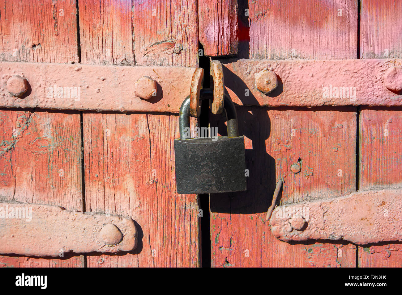 Old iron lock on weathered door painted in red color in Astrakhan ...