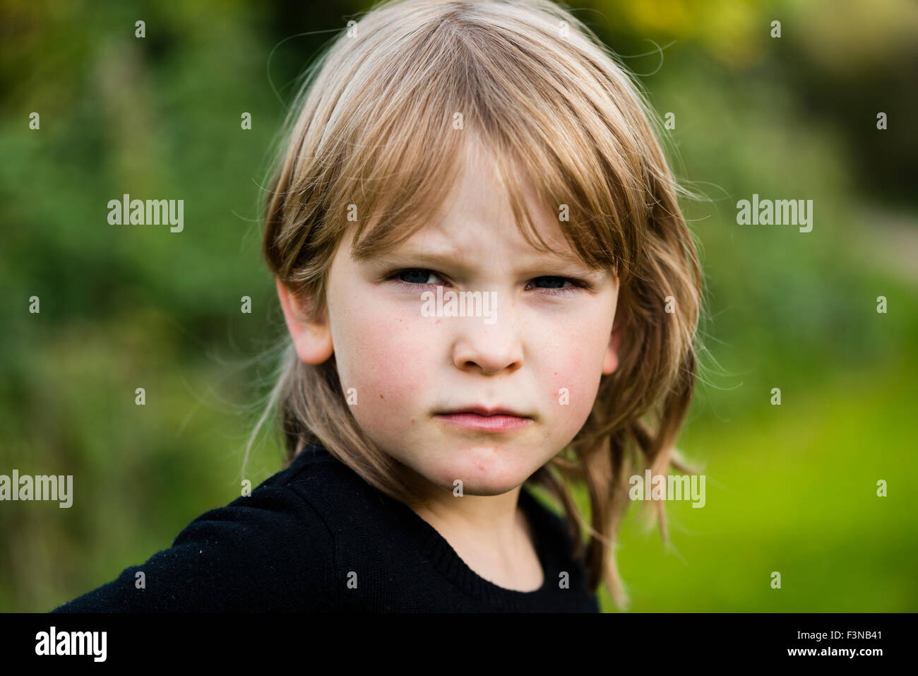 Child thinking and looking serious outdoors Stock Photo - Alamy
