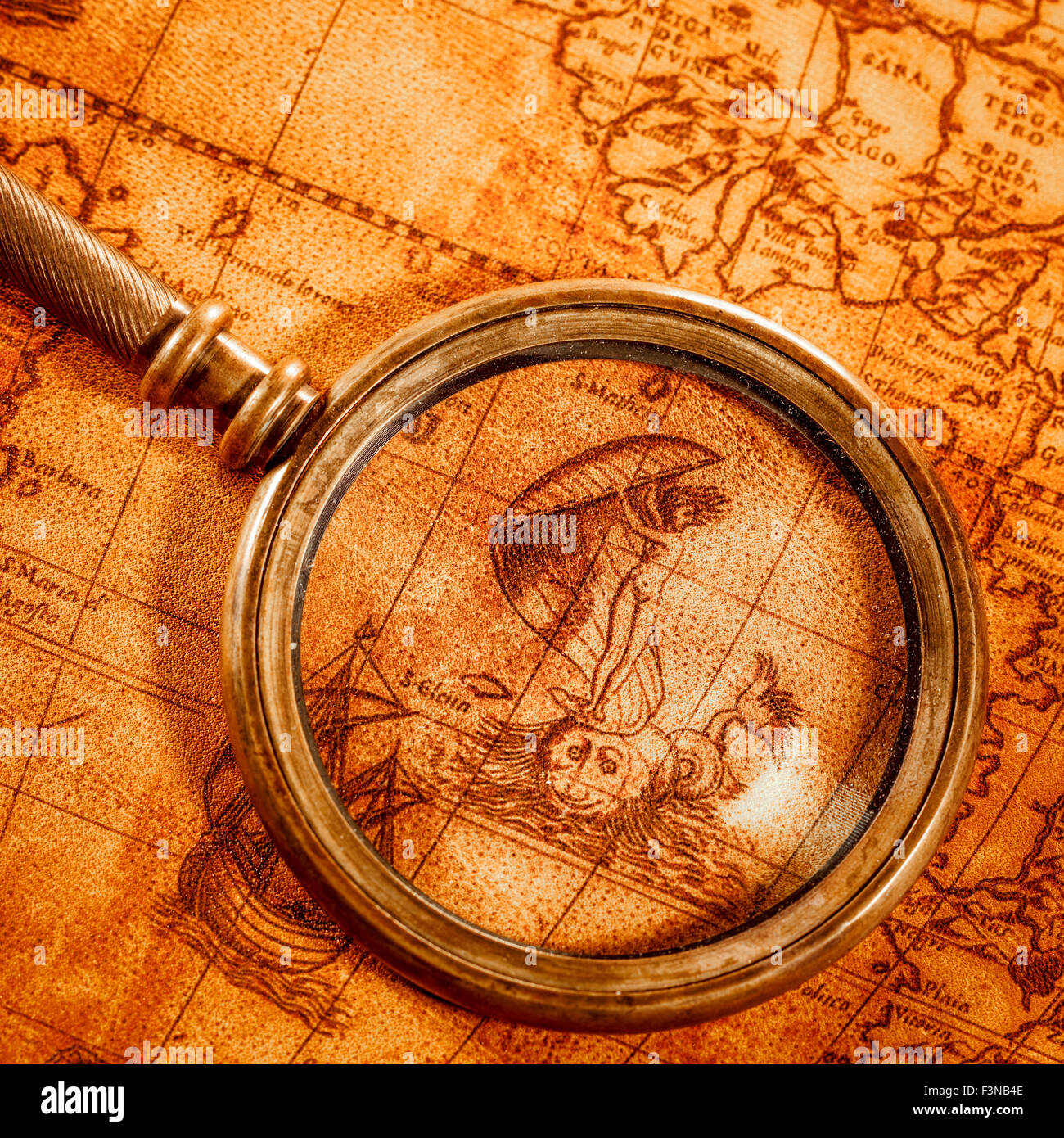 Vintage still life. Vintage magnifying glass lies on an ancient world ...