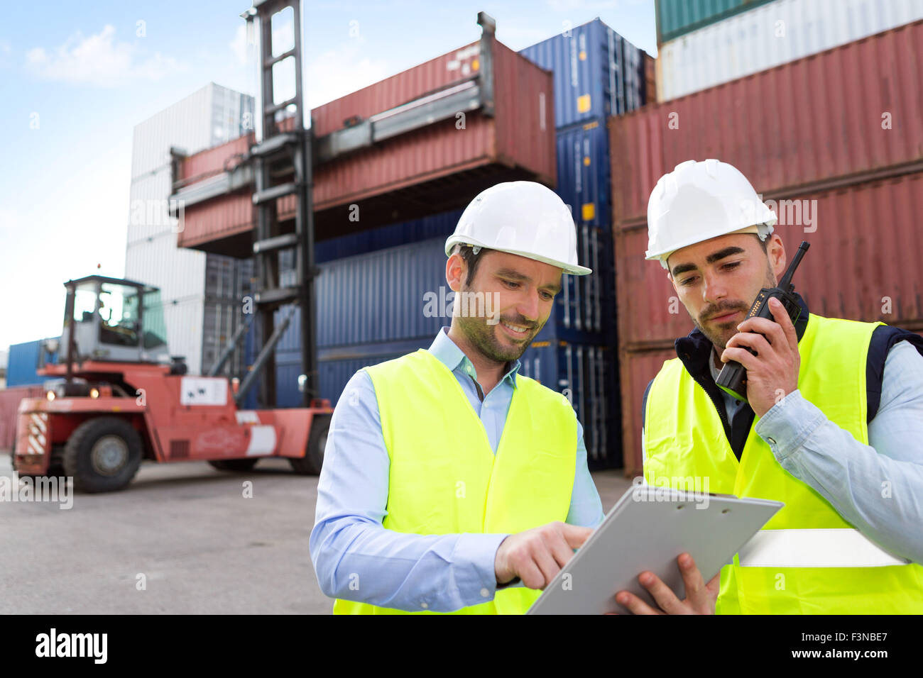View of a Dock worker and supervisor checking containers data Stock ...