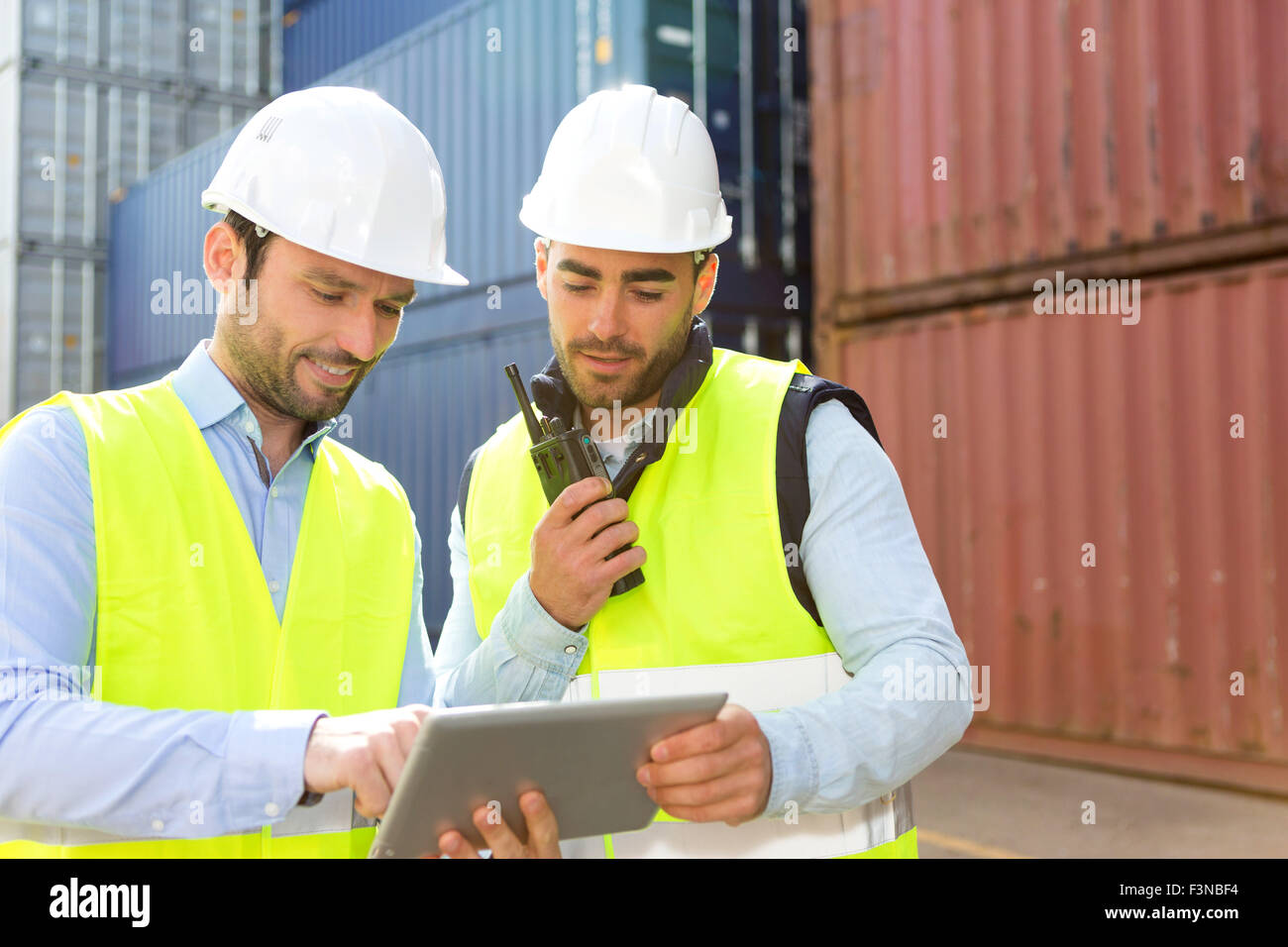 View of a Dock worker and supervisor checking containers data on tablet ...