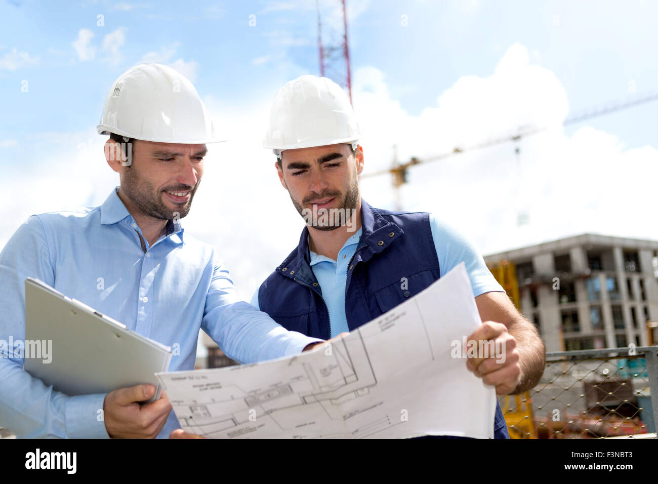 View of an Engineer and worker checking plan on construction site Stock ...