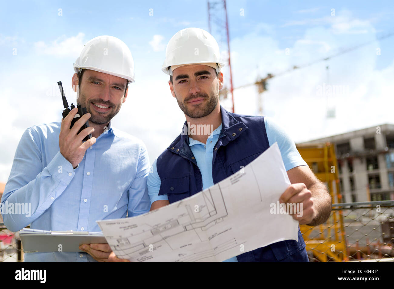 View of an Engineer and worker checking plan on construction site Stock ...