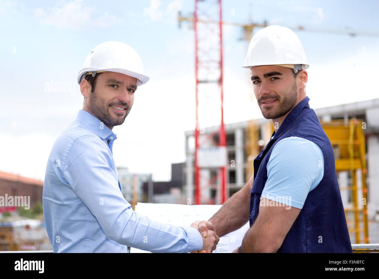 View of an architect and worker handshaking on construction site Stock ...