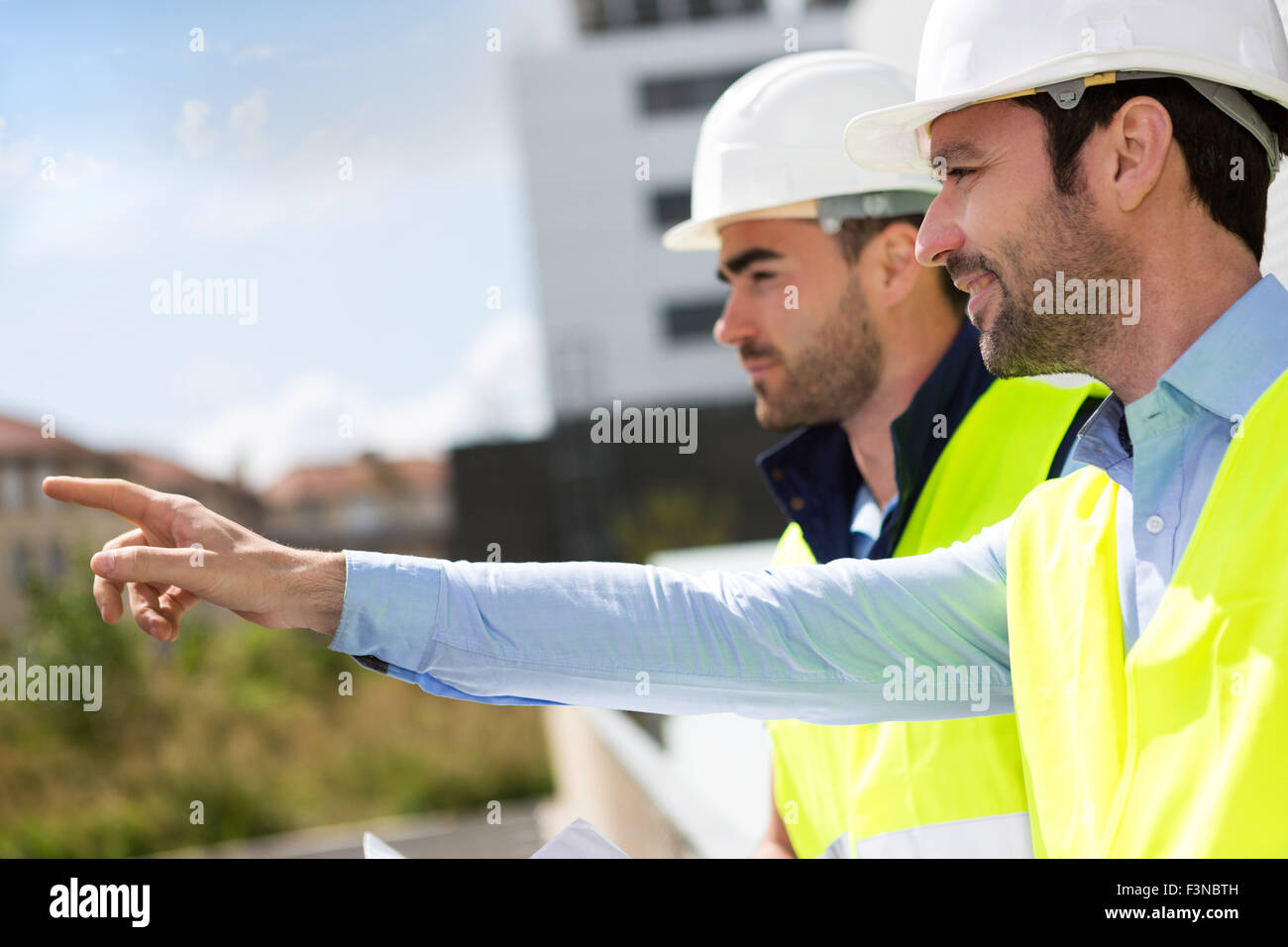 View of an worker and architect watching some details on a construction ...
