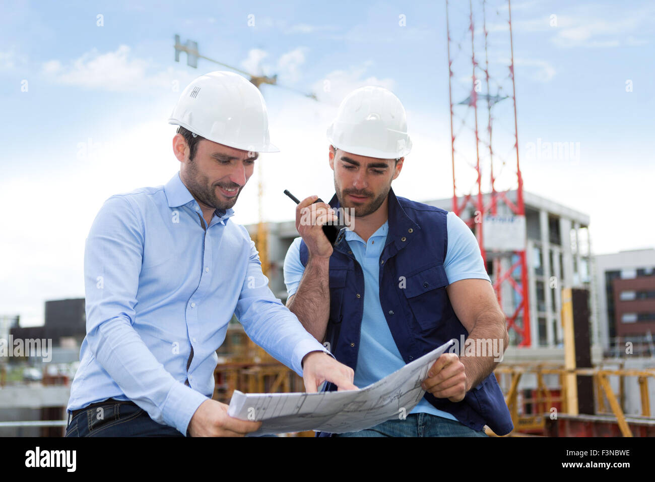 Engineer watching blueprint on construction hi-res stock photography ...