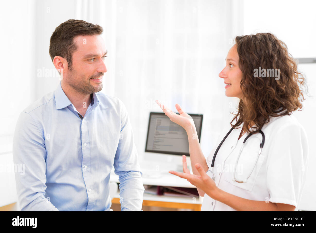 View of a Young attractive doctor listening his patient Stock Photo - Alamy
