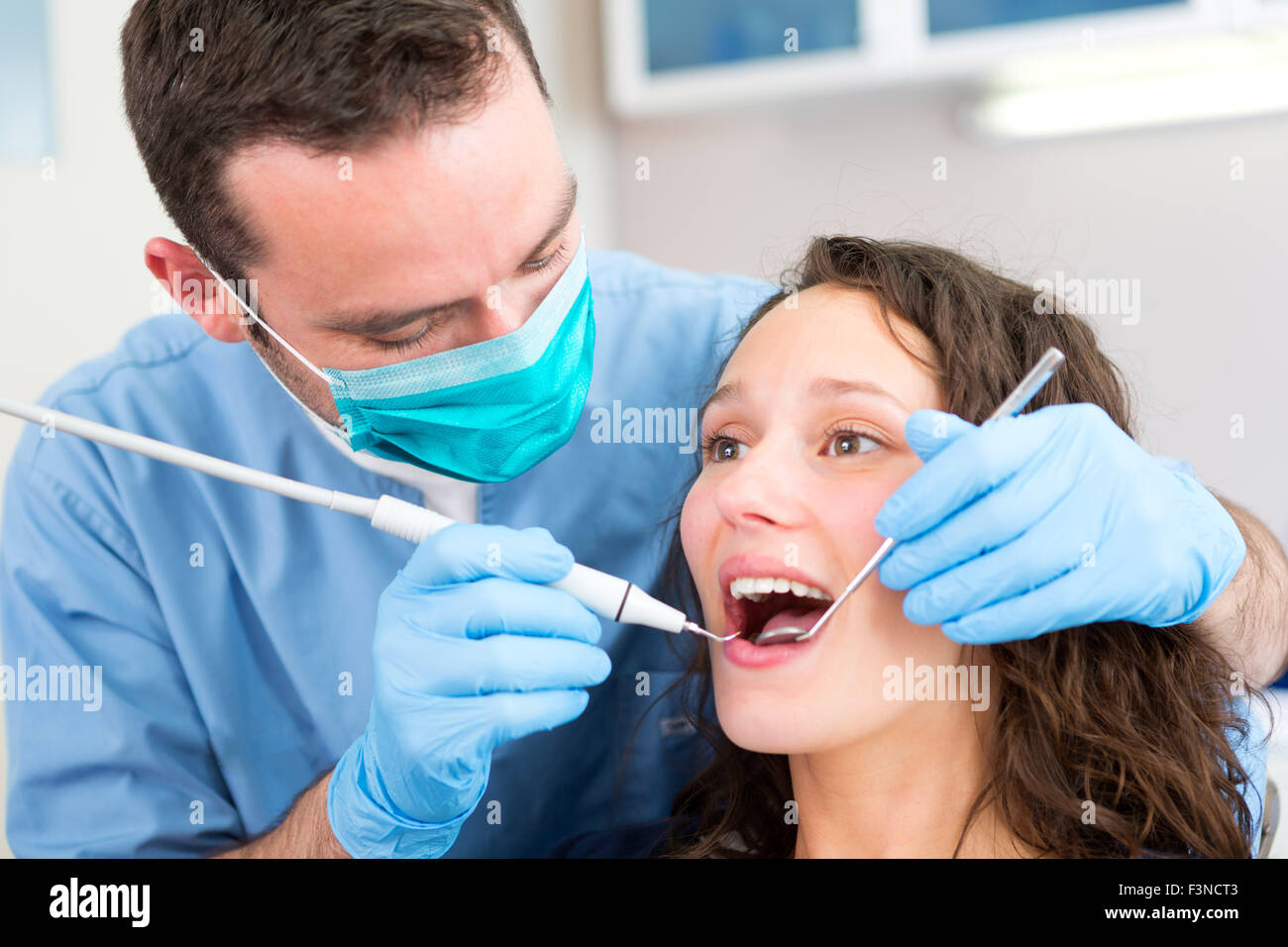 View of a Young attractive woman being cured by a dentist Stock Photo ...