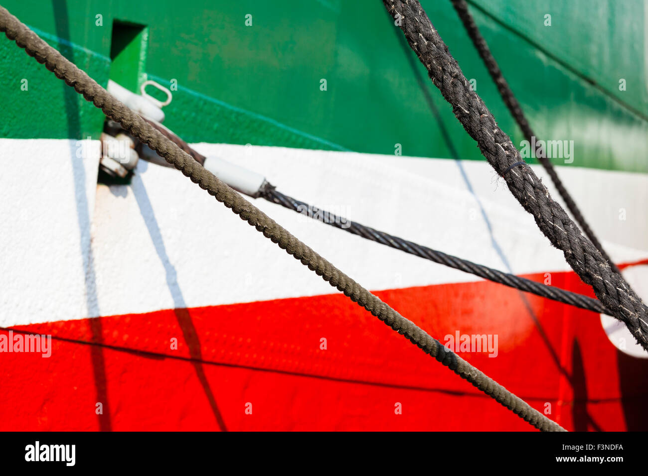 A colorful ship hull in green, white and red with some ropes Stock ...