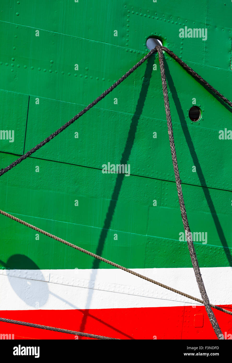 A colorful ship hull in green, white and red with some ropes Stock ...