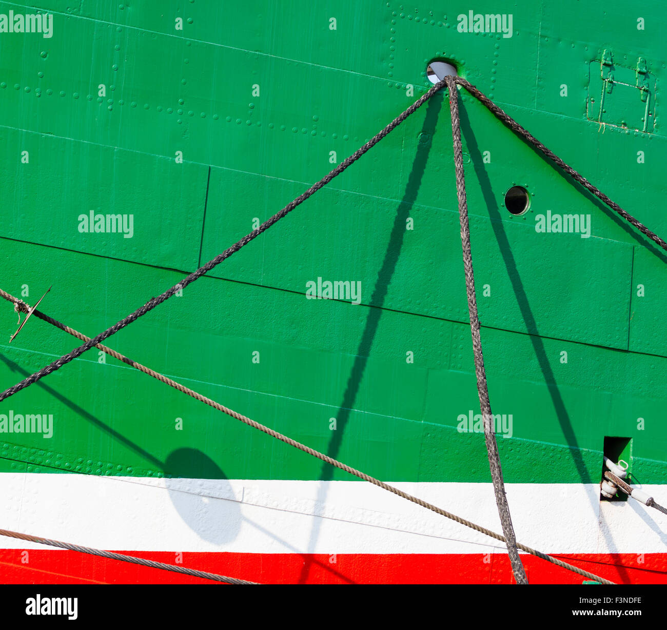 A colorful ship hull in green, white and red with some ropes Stock ...