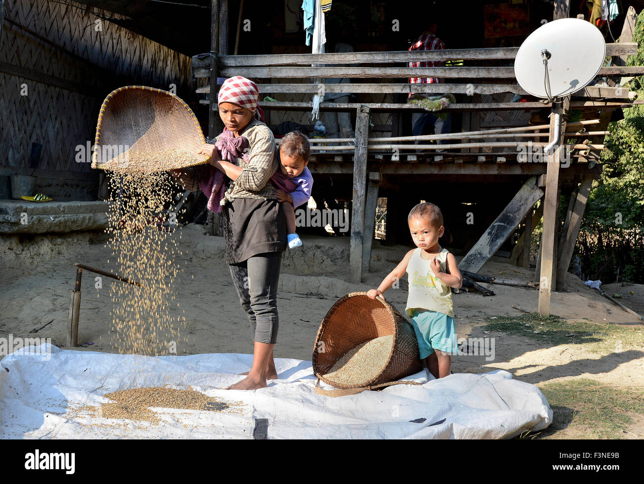 The rural village mother working with her child in front of their home ...