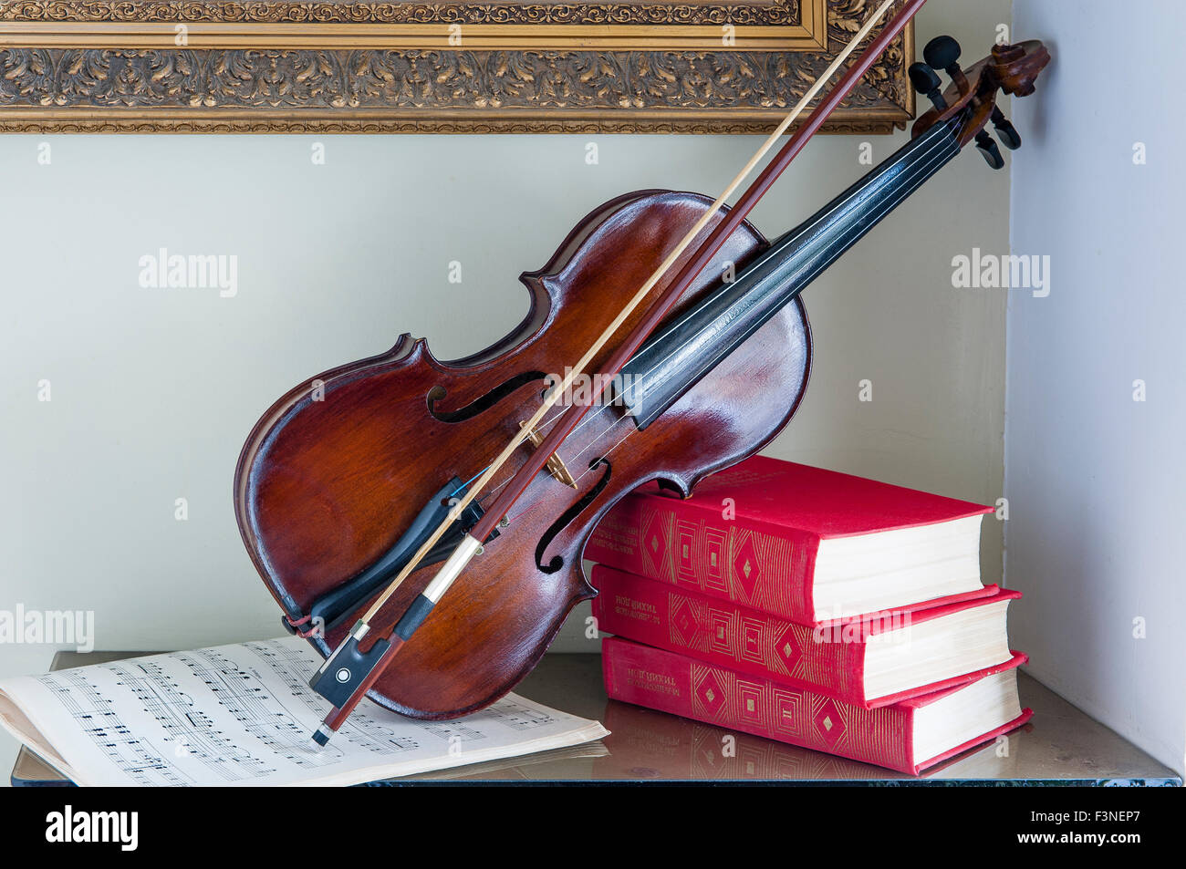 Violin notes and books stand on the table under the painting Stock ...