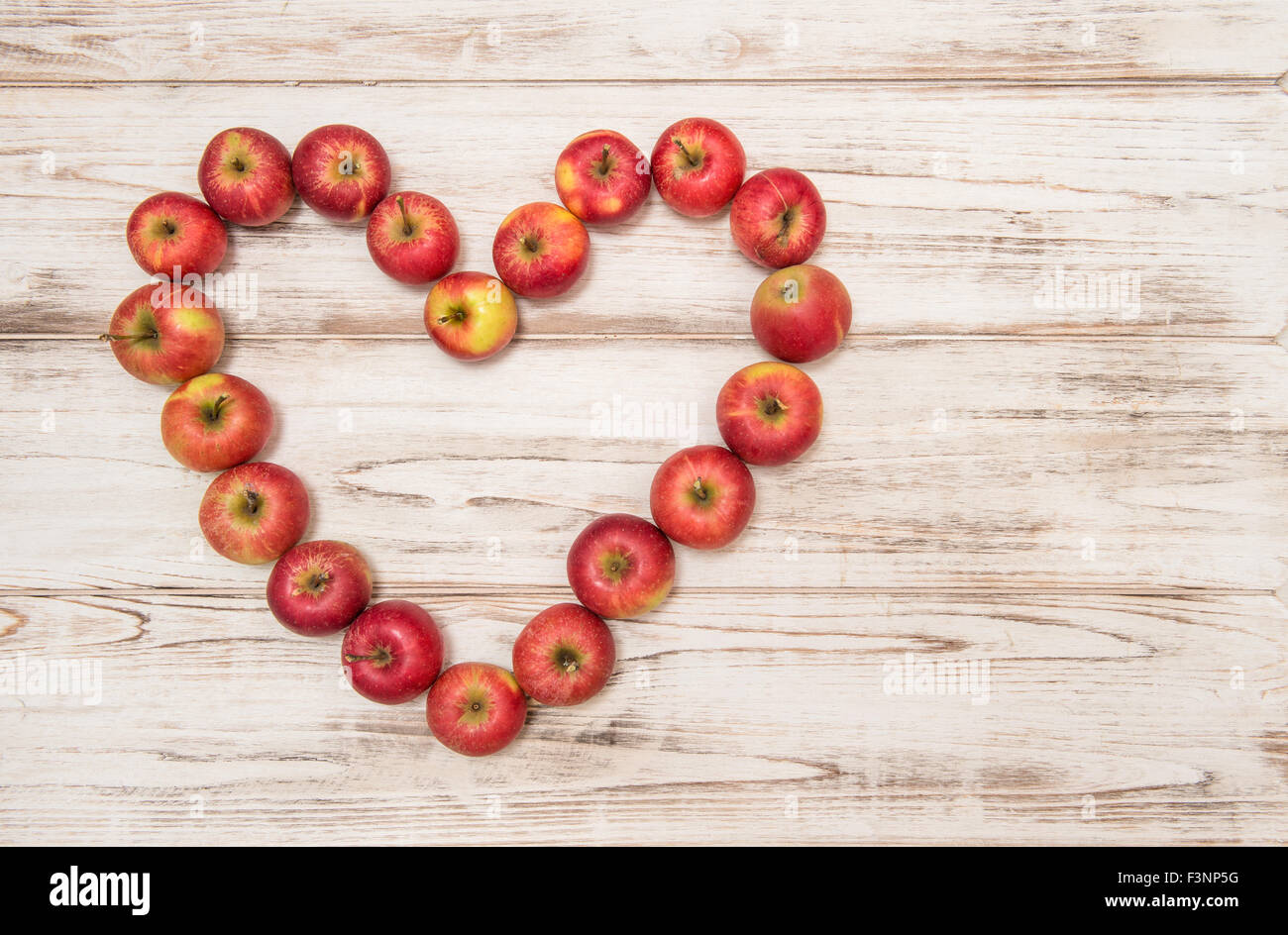 Apples in heart shape on rustic wooden background. Love concept Stock ...