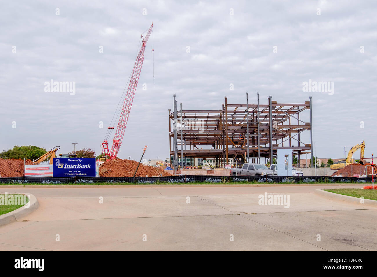 A crane stands beside steel framework for a commercial building in the ...