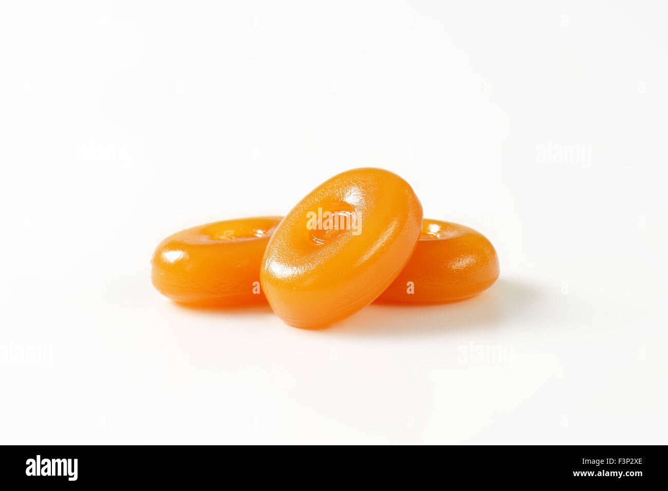 three caramel candies on white background Stock Photo - Alamy