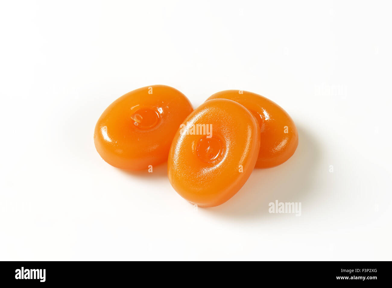 three caramel candies on white background Stock Photo - Alamy