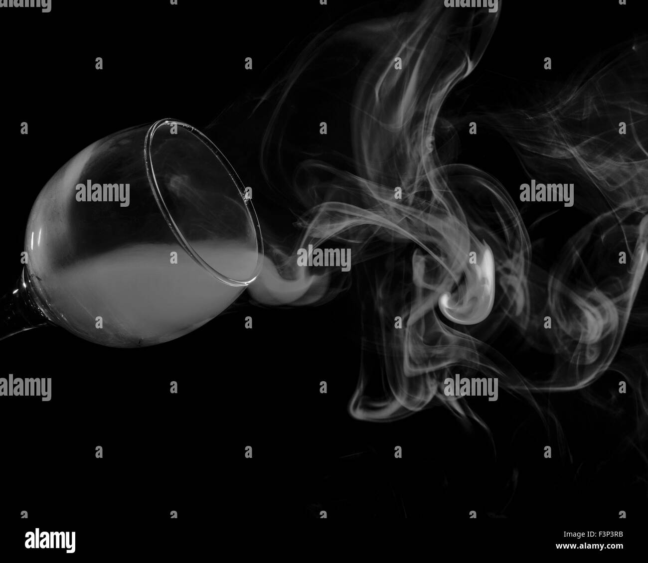 Abstract art. Hookah smoke into cocktail glass on a black background ...