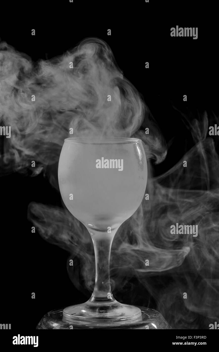 Abstract art. Hookah smoke into cocktail glass on a black background ...